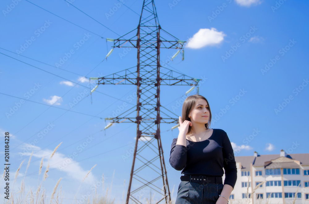 Beautiful young girl on electric pole background. Energy, electricity ...