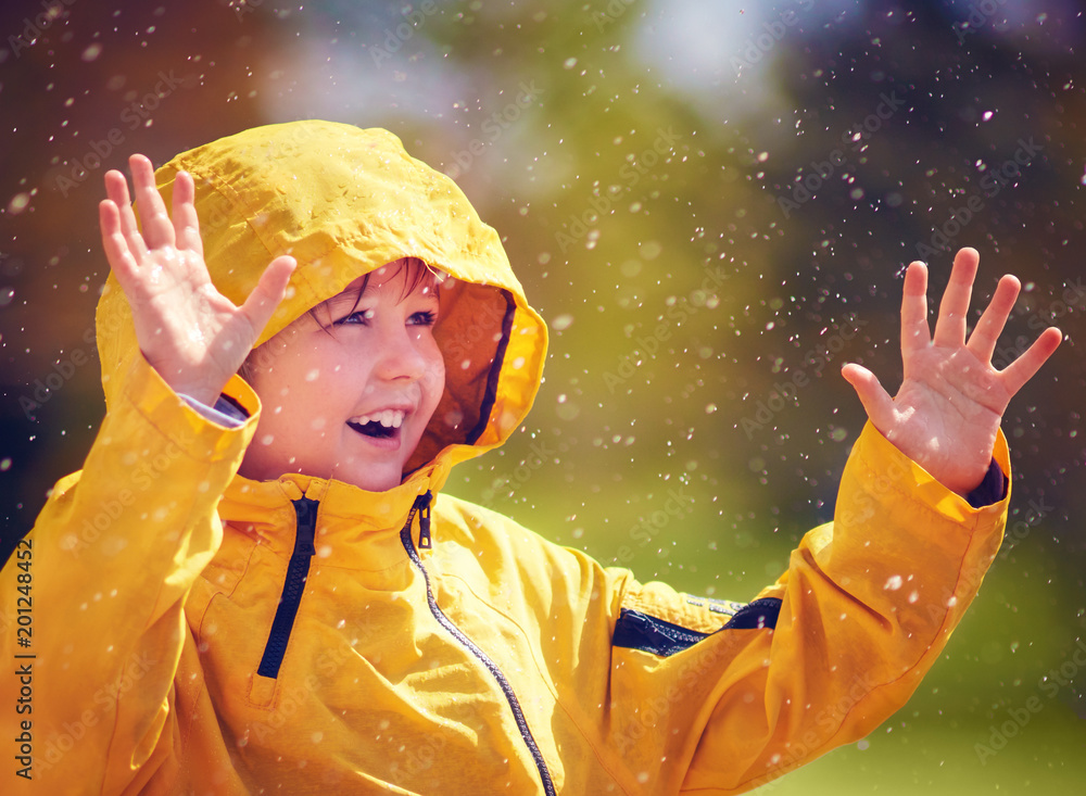 happy kid catching rain drops in spring garden Stock-Foto | Adobe Stock
