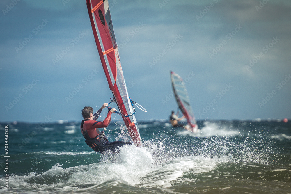 Surfer riding waves in a beautiful sunny day. Young man enjoying the ...