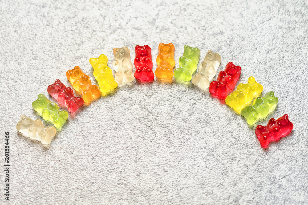 half circle frame from fruit gummy bears candies, top view on a grey ...