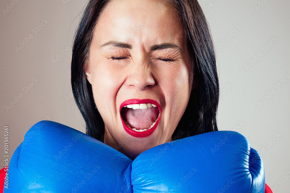 portrait of a beautiful brunette woman with a furious face with boxing ...