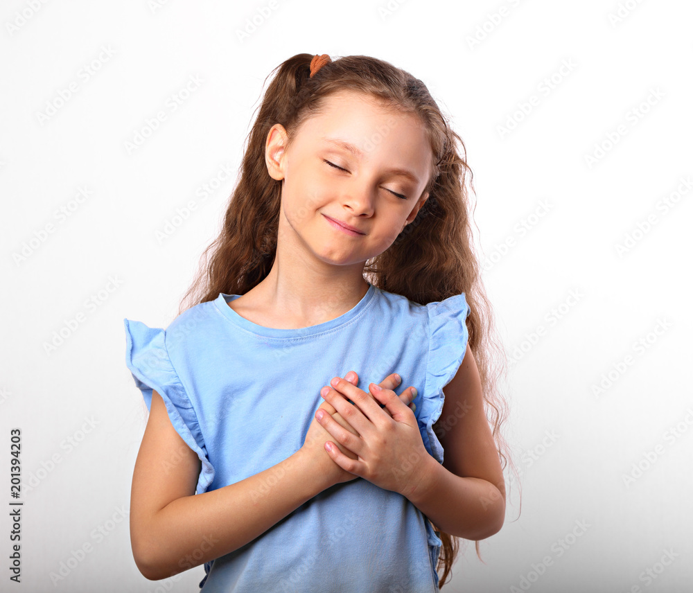 Beautiful kid girl in love holding herself chest and heart two hands ...