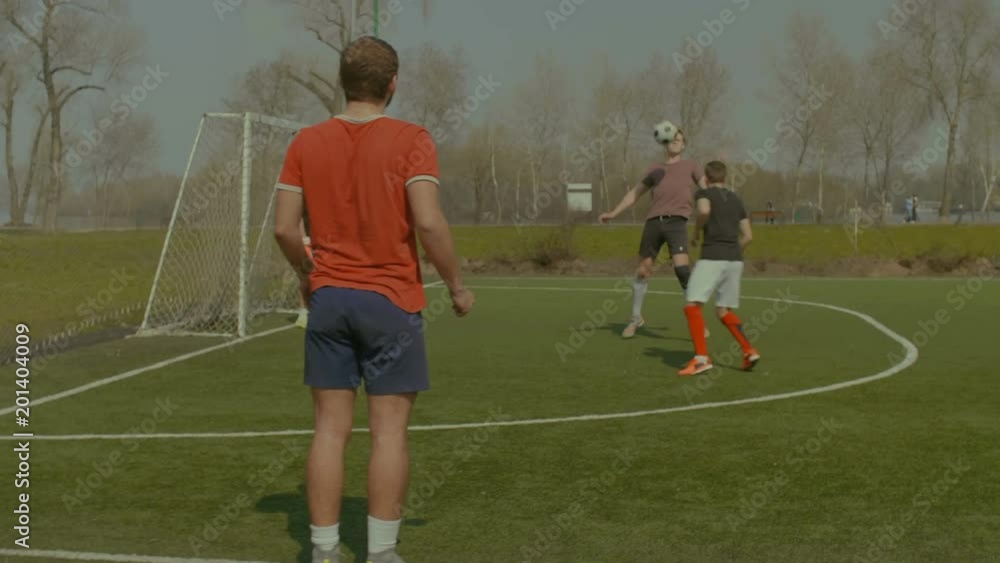 Rear view of young soccer player making throw-in onto the pitch during ... Rear view of young soccer player making throw-in onto the pitch during ...