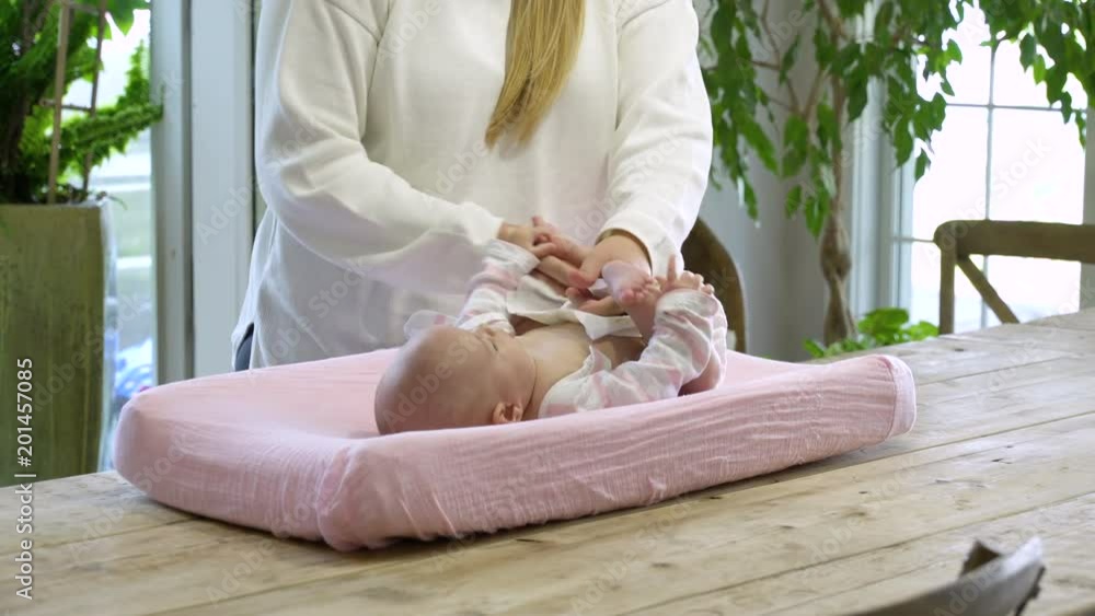 Mother changing baby girl's diaper, side view. Stock Video | Adobe Stock