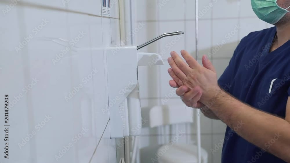 Doctor disinfects and washing his hands dry before entering the ...