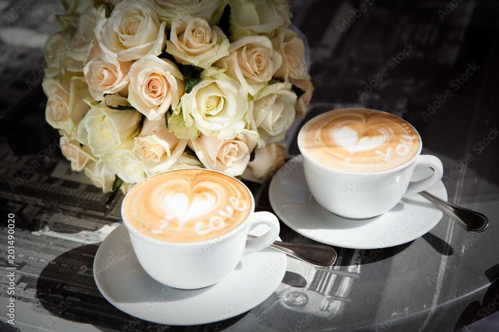 Two cups of coffee with a heart pattern for couple in love are in cozy ...