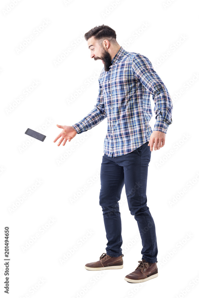Screaming shocked young bearded man dropping mobile phone falling on ...