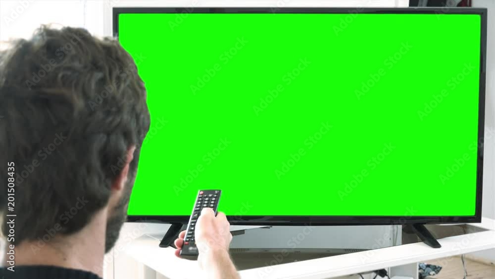 Changing Channels TV Green Screen. Young man changing channels with a ...