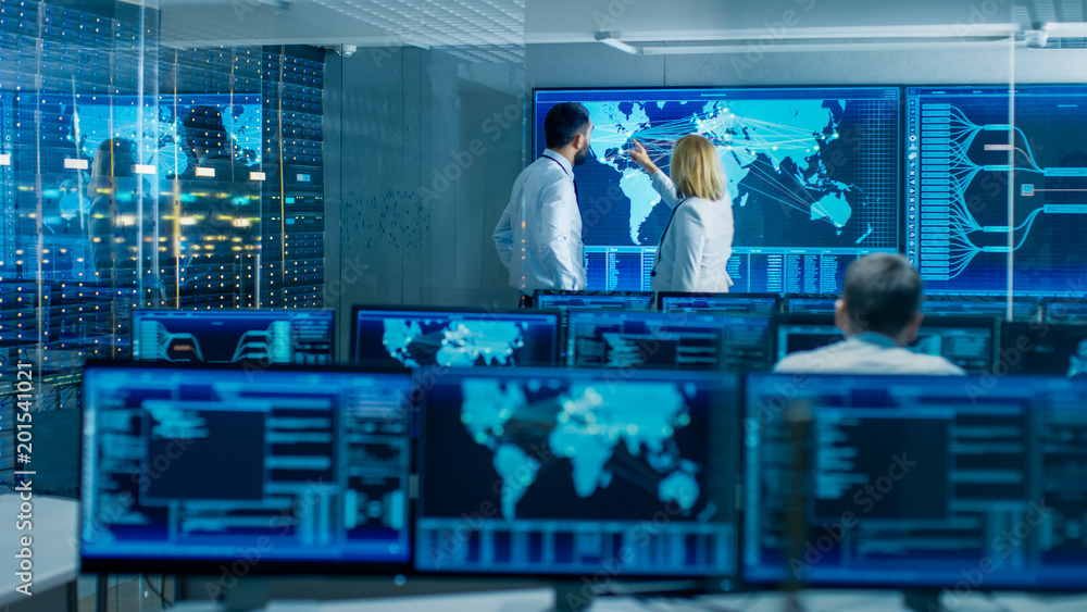 In the System Monitoring Room Two Senior Operators Work on a Big ...