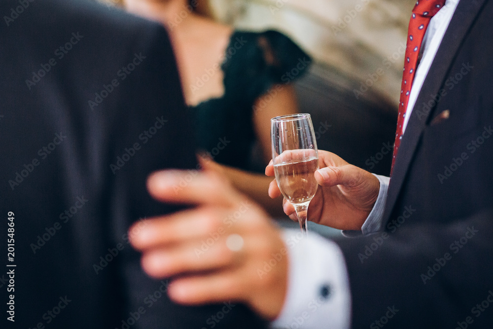 group of elegant people holding glasses of champagne at luxury wedding ...
