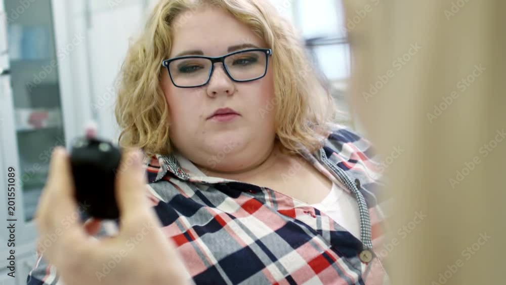 Tilt up of female doctor showing glucose meter to obese diabetic ...