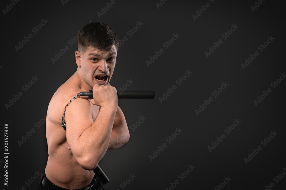 View of a muscled man on a black background in single combat weapon ...
