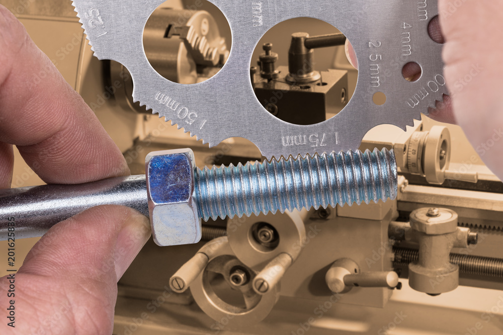 Measuring by screw pitch gauge with lathe in background. Measurement of ...