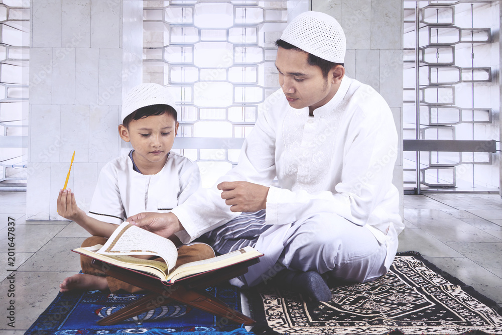 Father teaching his son to read the Quran Stock Photo | Adobe Stock