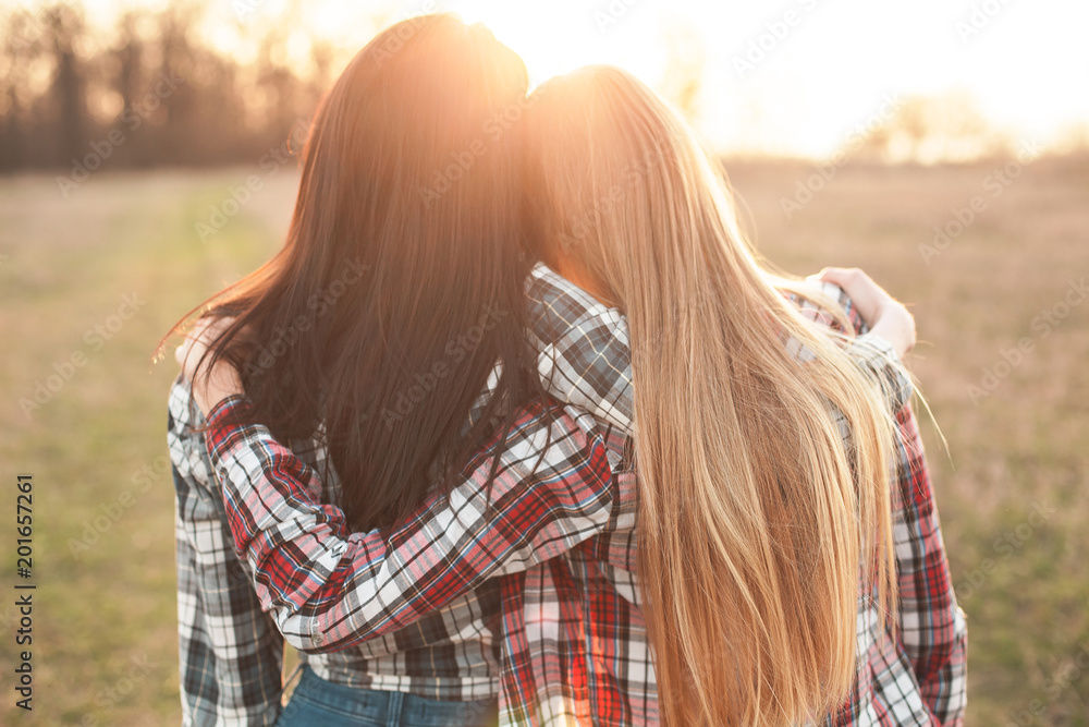 Two young woman looking on the sunset and hugging. Best friends Stock ...