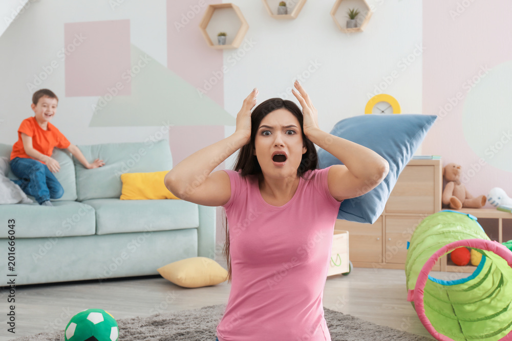 Young nanny in despair and troublesome child at home Stock Photo ...