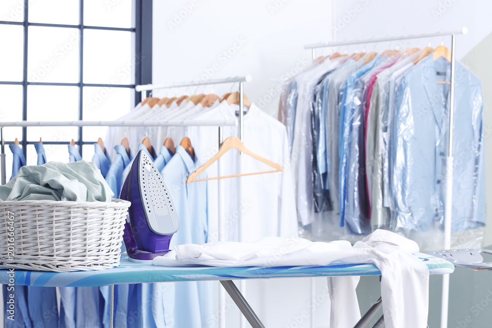 Wicker basket with clothes on ironing board at dry-cleaner's Stock ...
