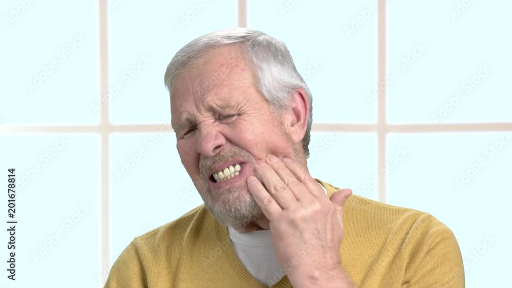 Unhappy older man suffering from tooth ache. Old man touching his cheek ...