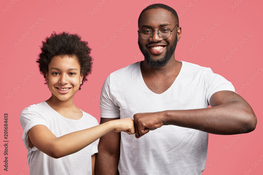 Shot of happy smiling father and son with pleasant smile greet happily ...