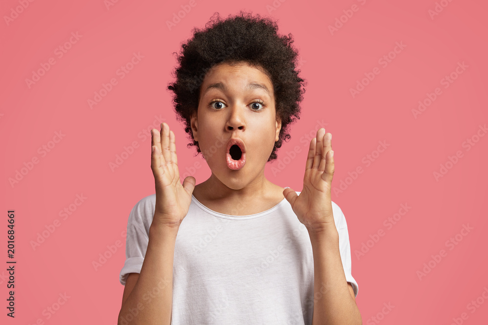 Scared astonished mixed race African male child with bushy hairstyle ...