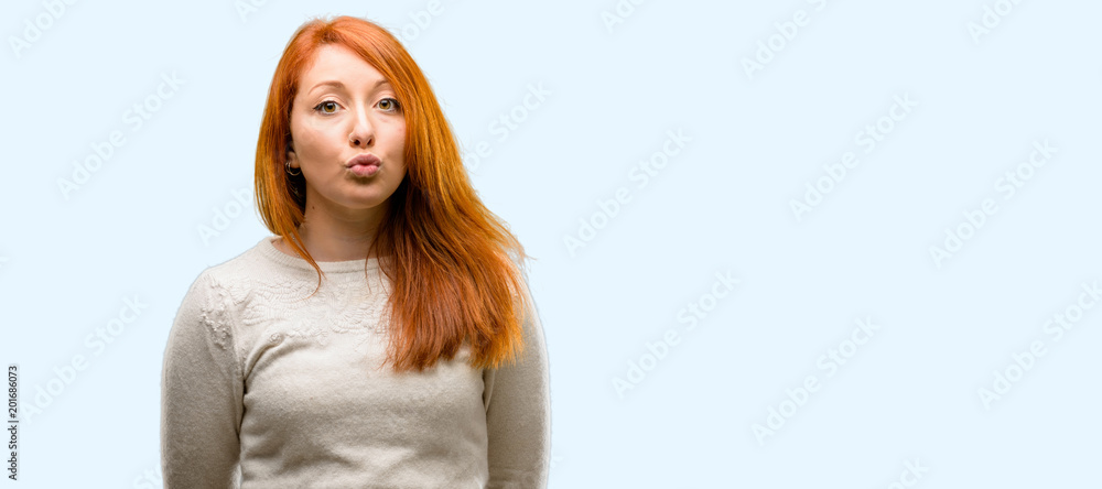 Beautiful young redhead woman expressing love, blows kiss at camera ...