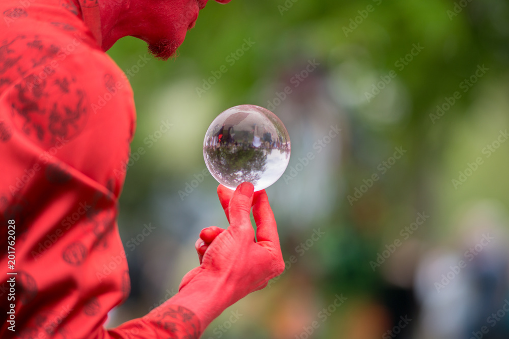 man with red hands dressed as the devil holds and plays with an ...