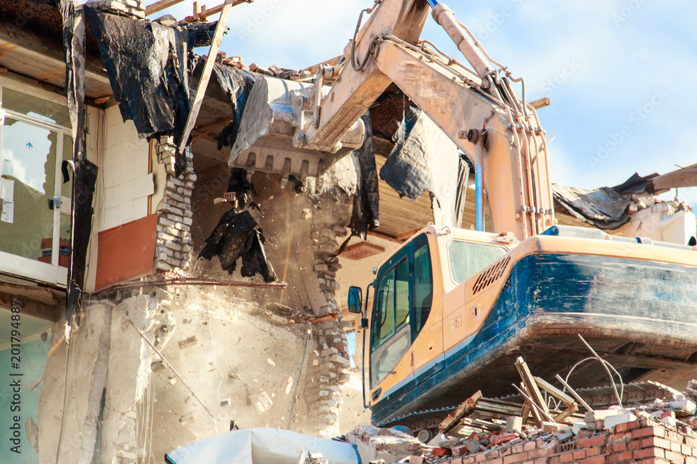 excavator destroys and ruins the building on a bright sunny day Stock ...