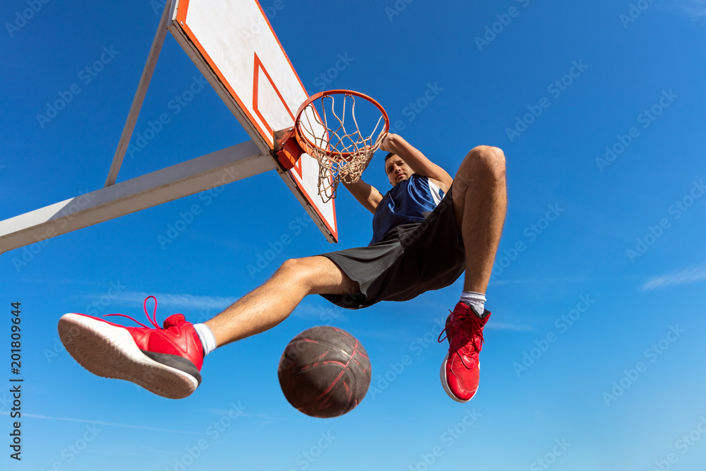 Slam Dunk. Side view of young basketball player making slam dunk Stock ...
