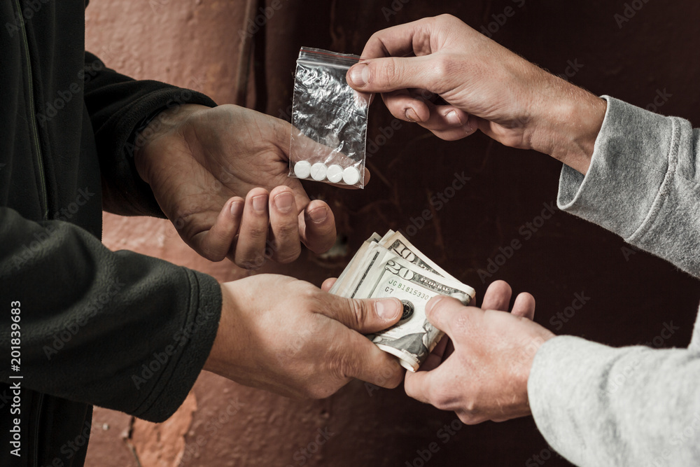 Hand of addict man with money buying dose of cocaine or heroine or ...