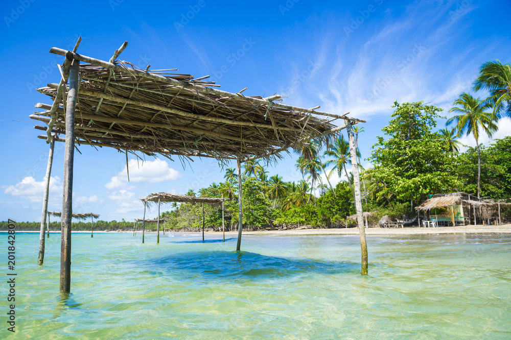Rustic palm frond and tree branch palapa umbrella waiting to shade ...