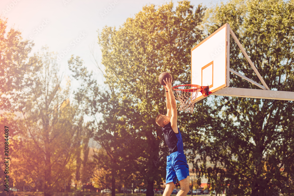 Street basketball player performing power slum dunk Stock Photo | Adobe ...