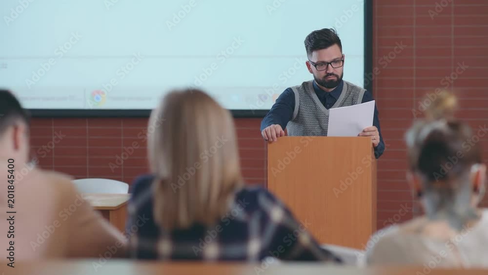 Video Stock A young university professor stands behind the podium and ...