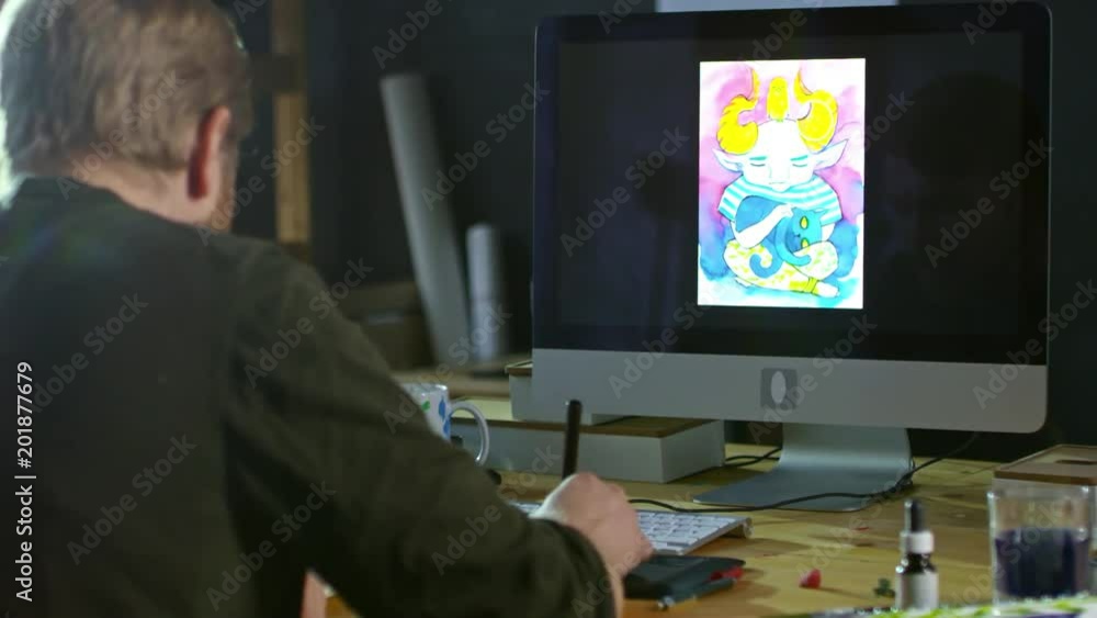 Tracking shot of young man using drawing tablet and computer software ...