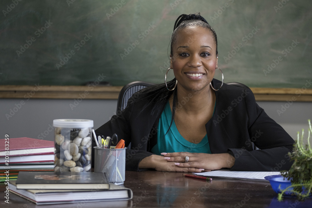 Portrait of a proud black female teacher at her desk Stock Photo ...