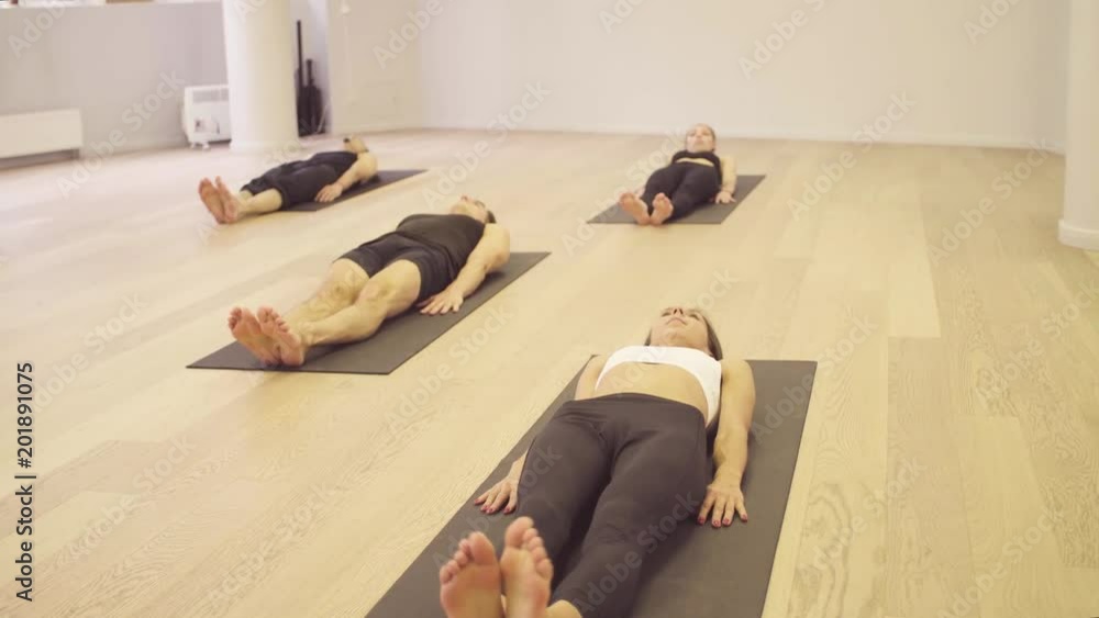Yoga class. People doing yoga asanas in bright studio. Ashtanga yoga ...