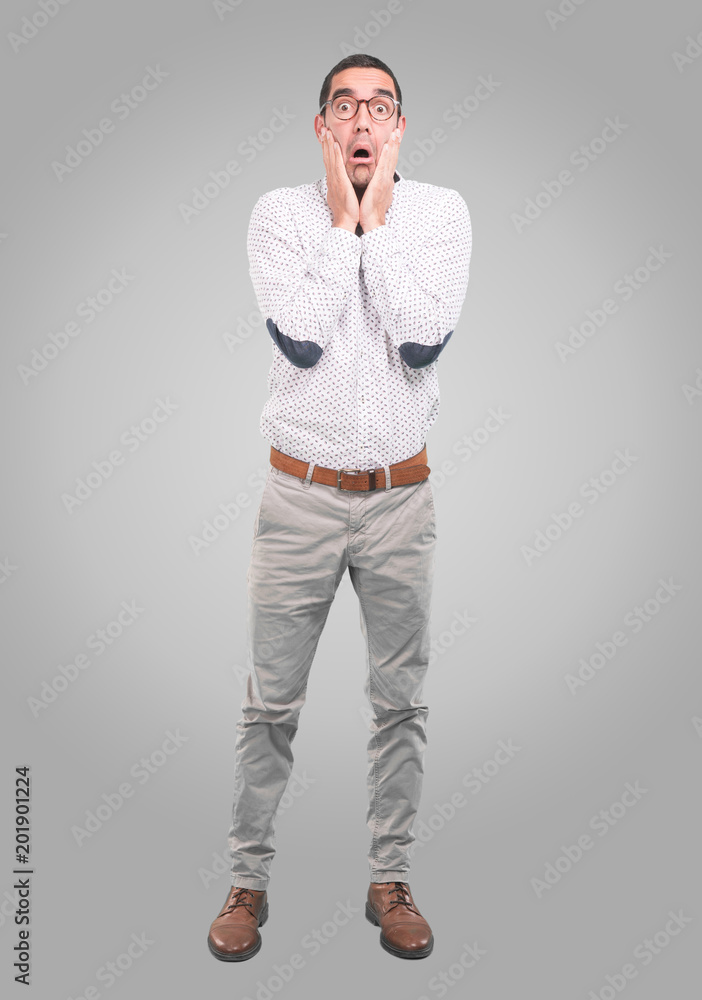 Shocked young man with a gesture of surprise with his mouth openend ...