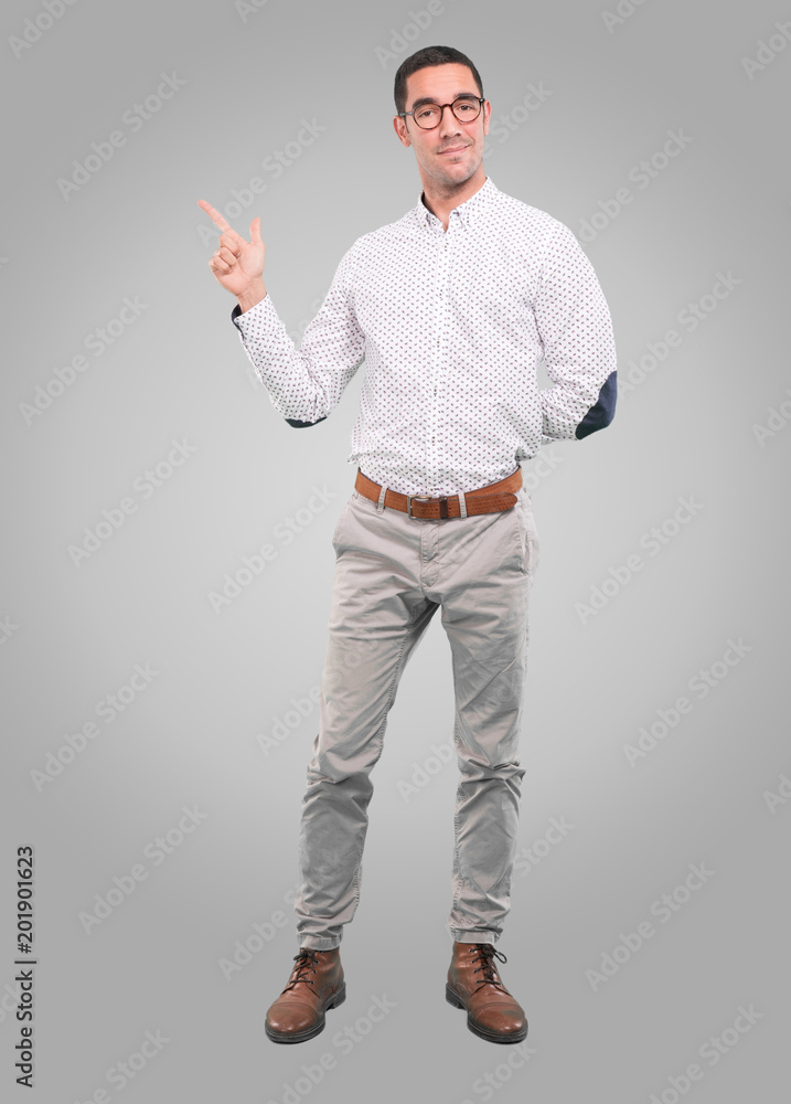 Confident young man pointing with his hand - Full body shot Stock Photo ...