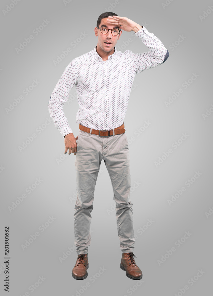 Astonished young man with a gesture of looking far - Full body shot ...