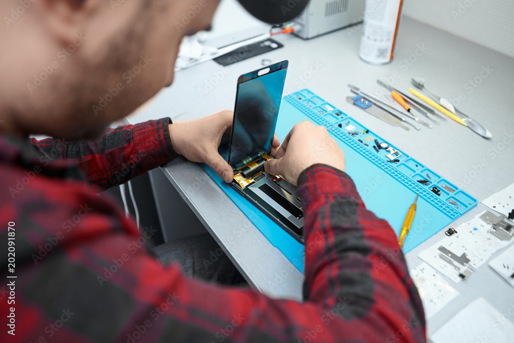 Skilled professional male technician from electronics repair service ...