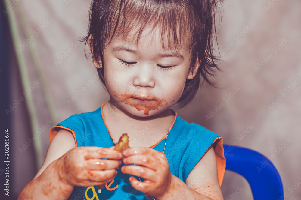 Child eating with a stained face. Do it yourself concept. Vintage tone ...