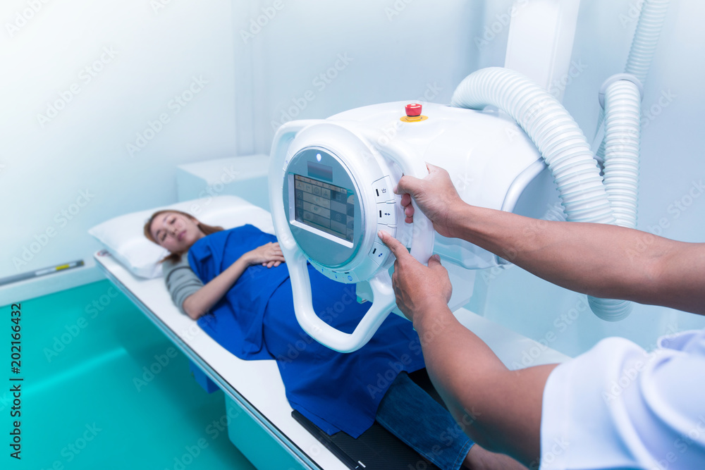 Young asian woman patient lying down in x-ray machine. radiography ...