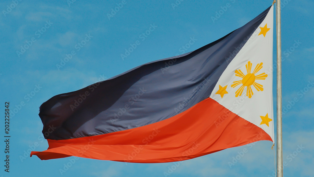 Flying bicolor flag of the Philippines with central golden sun ...