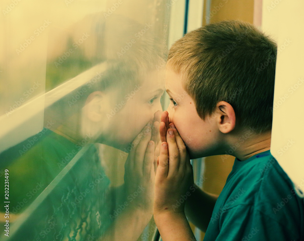 Cute 10 year old autistic boy looking at the rain Stock-Foto | Adobe Stock