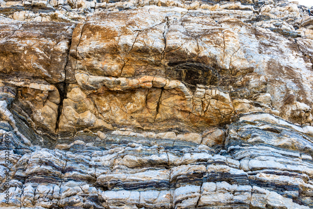 Compressed rock layers formation in various colors and thicknesses, on ...