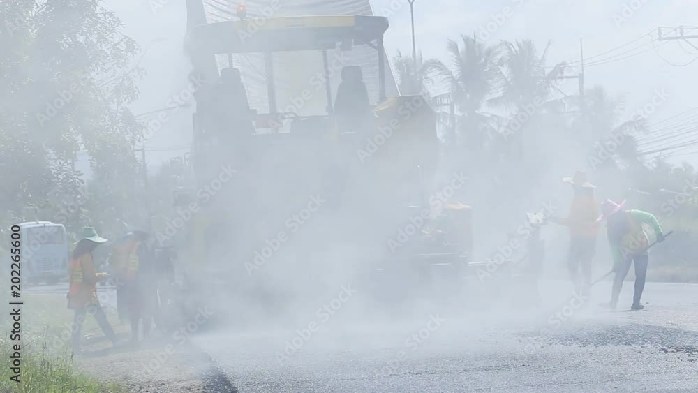 people are working and operating the process of building new asphalt ...