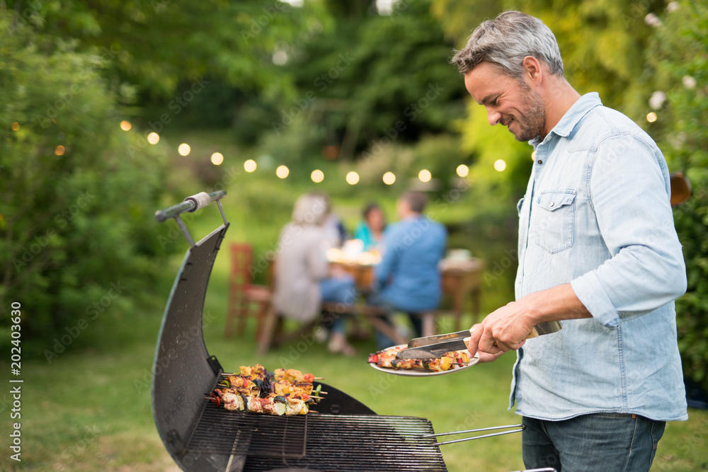 Foto de in the summer, a handsome man in his forties prepares a ...