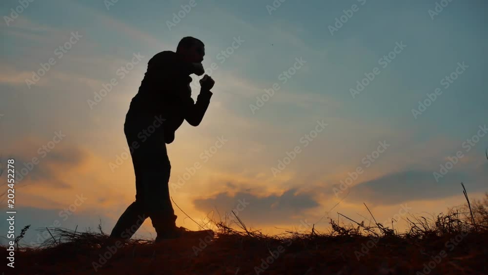 Vidéo Stock man boxer boxing on nature silhouette sunset sunlight ...