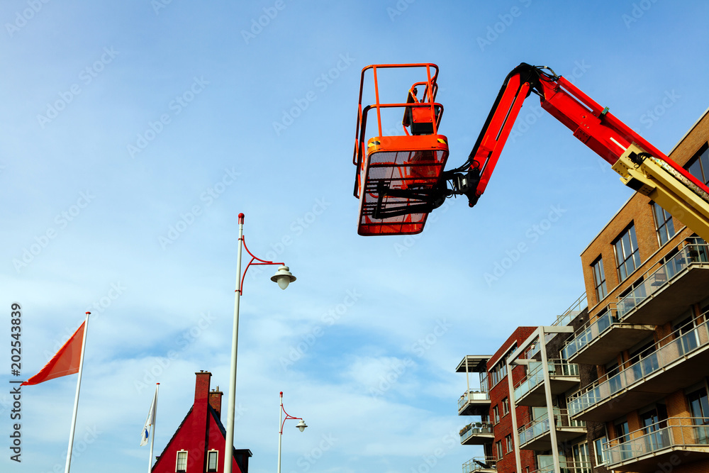 Red blue sky background boom lift construction hoist house old new ...