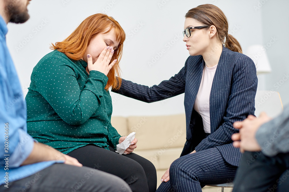 Highly professional psychiatrist comforting her crying obese patient ...