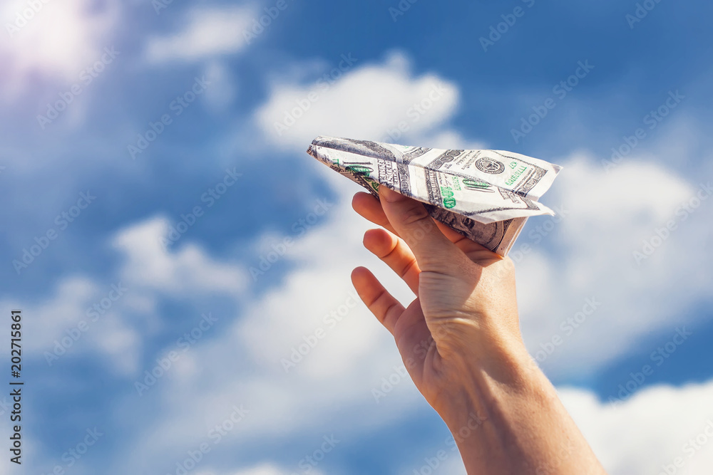 Money plane on the fingers over sky with clouds Stock Photo | Adobe Stock